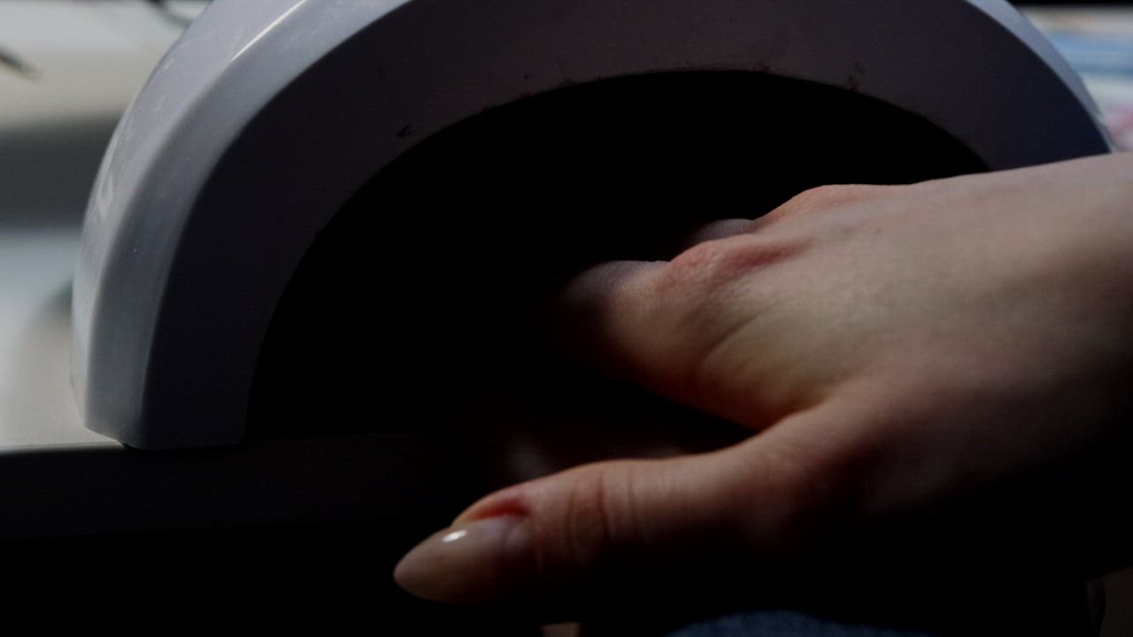 A woman hand in a UV lamp - Free Stock Video
