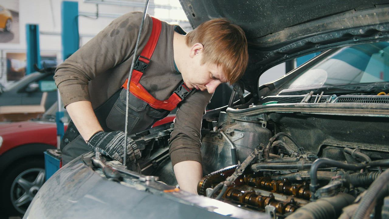 Mechanic working under the hood of a car - Free Stock Video