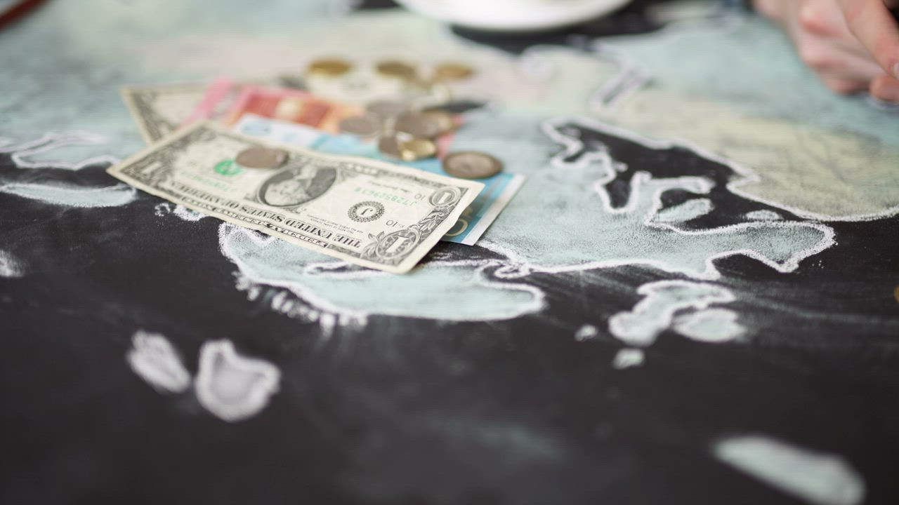 Hands using mobile on map with money and compass - Free Stock Video