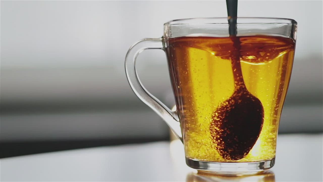 Spoon stirring sugar in clear glass tea cup - Free Stock Video