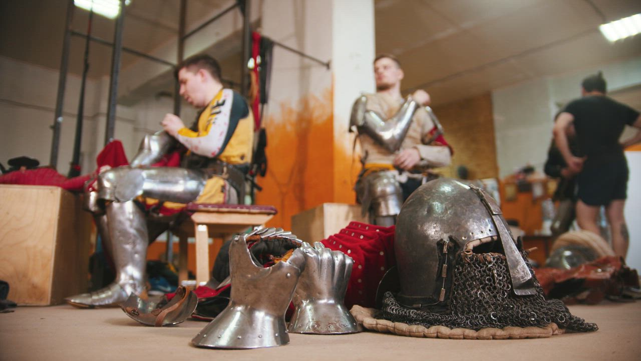 Men in the dressing room taking off the armor - Free Stock Video