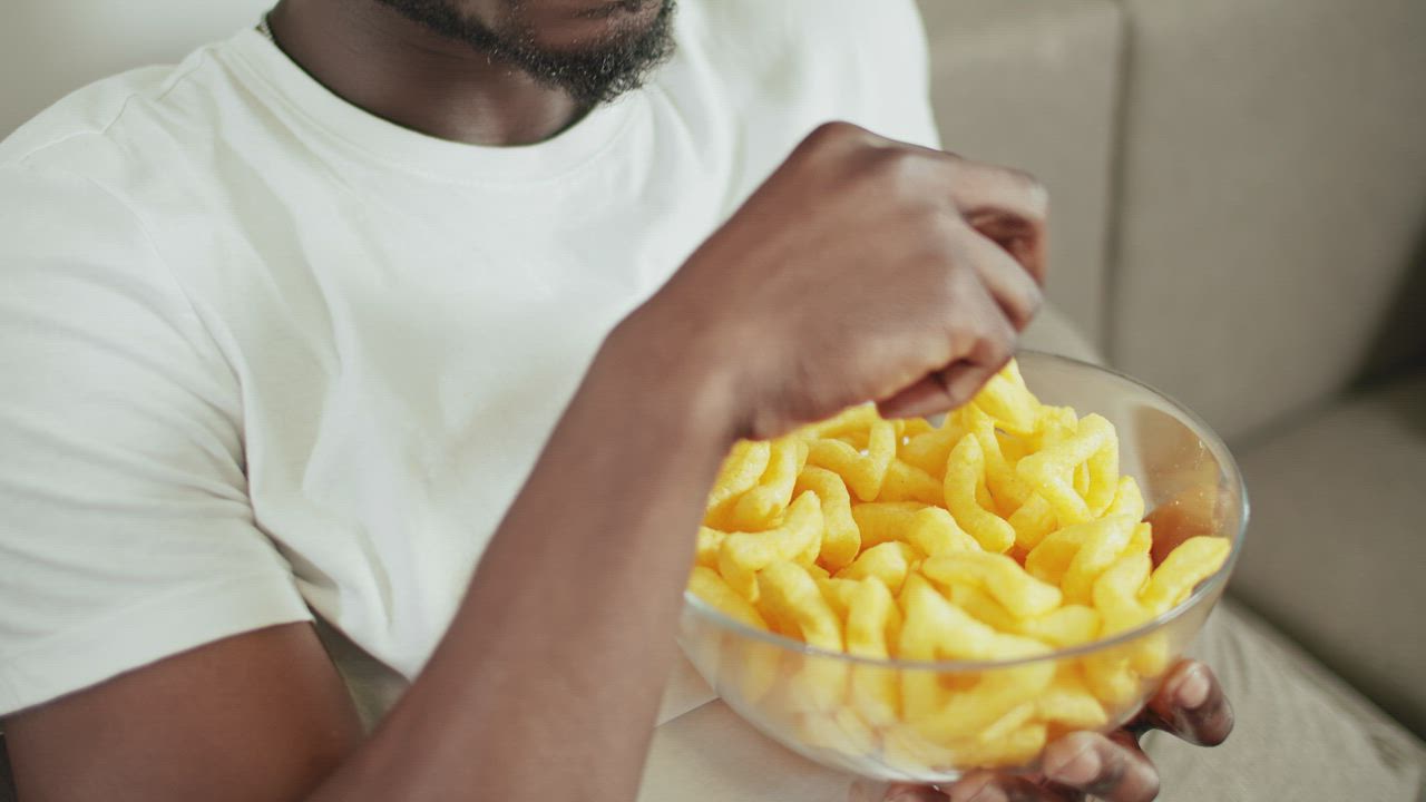 Smiling man watches movie and eats snacks - Free Stock Video