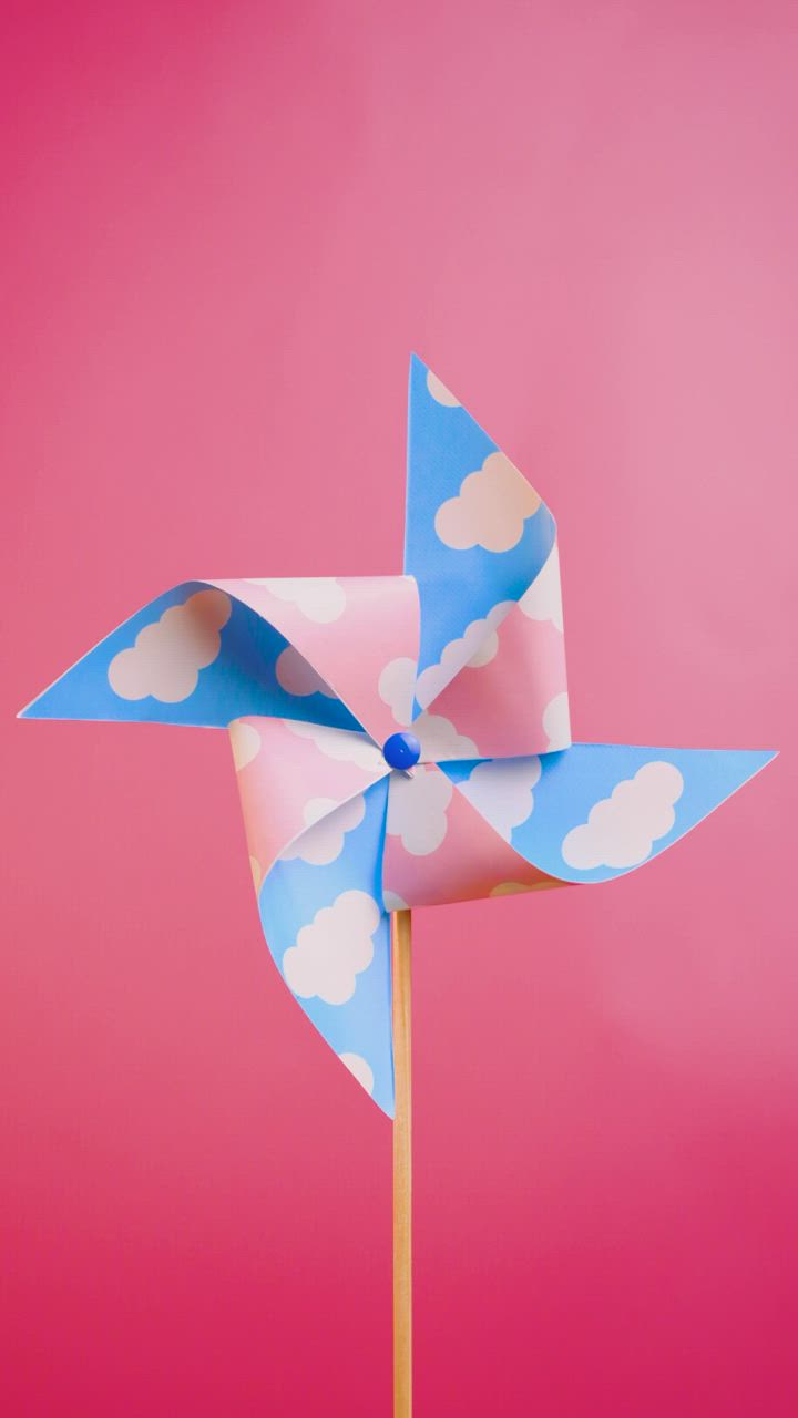 A pinwheel spinning on a pink background - Free Stock Video