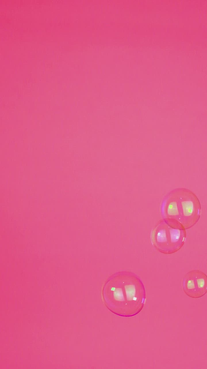 Bubbles floating on a pink background - Free Stock Video