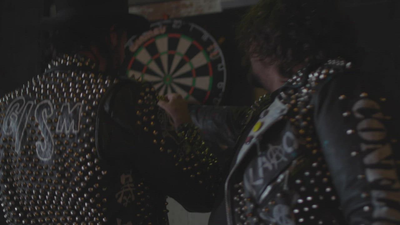 Men remove darts from a board - Free Stock Video
