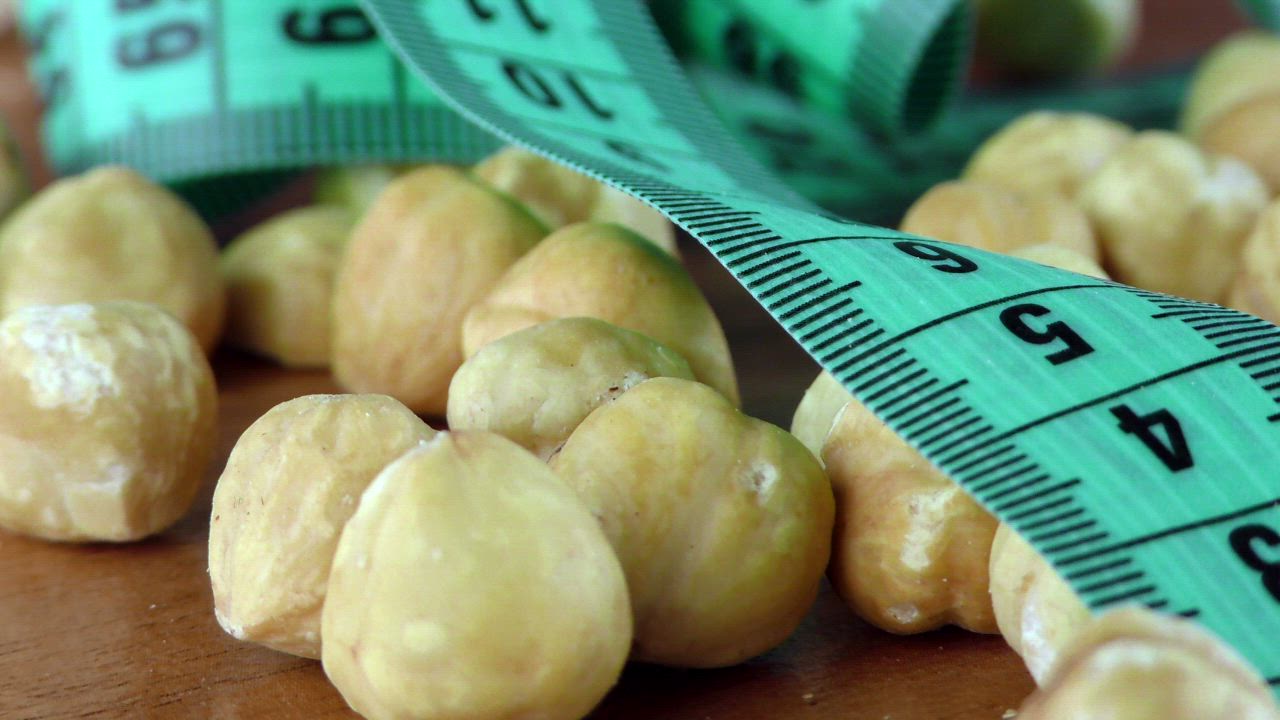 Hazelnuts and measuring tape, macro - Free Stock Video