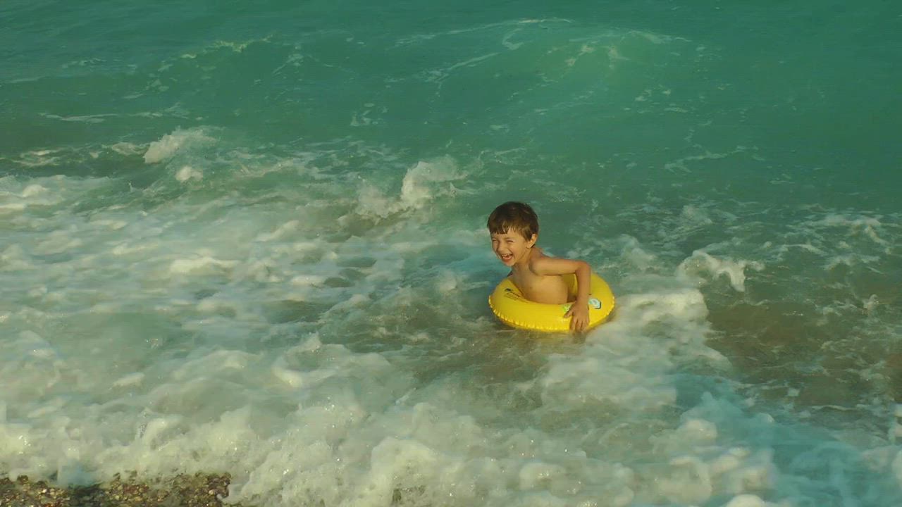 Boy in the seashore with a floaty - Free Stock Video