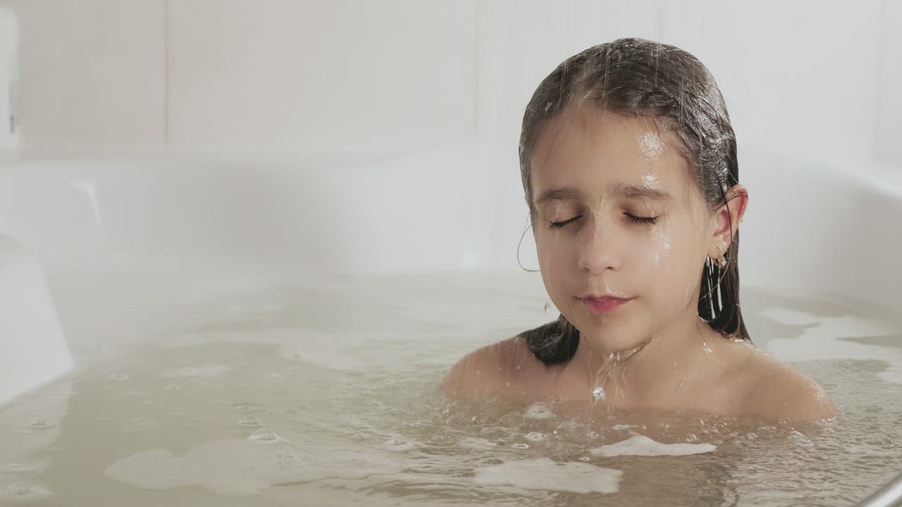 Little girl dipping her hair in the tub - Free Stock Video