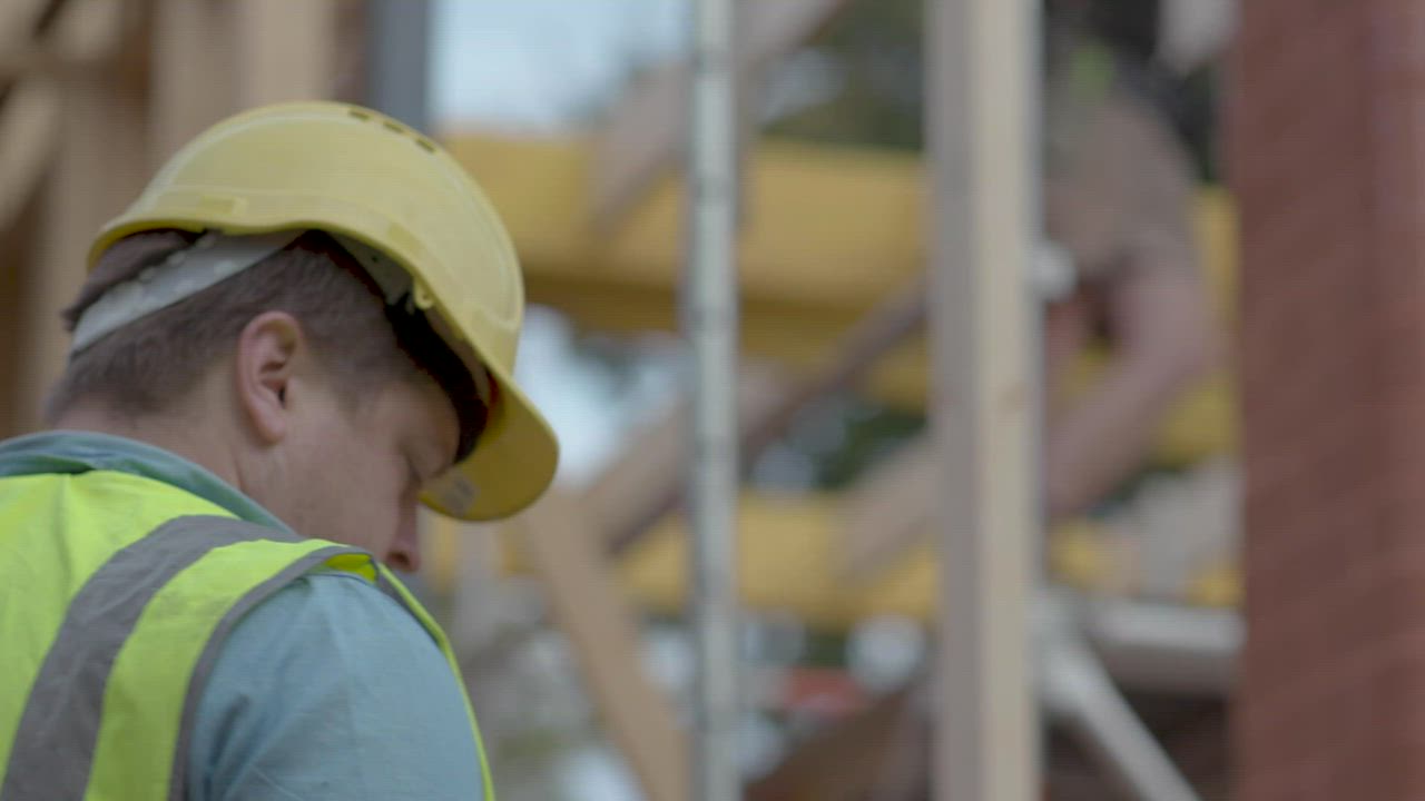 Person takes a phone call at a construction site - Free Stock Video