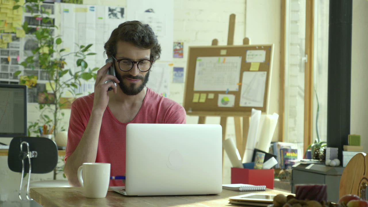 A man in the studio on a phone call - Free Stock Video