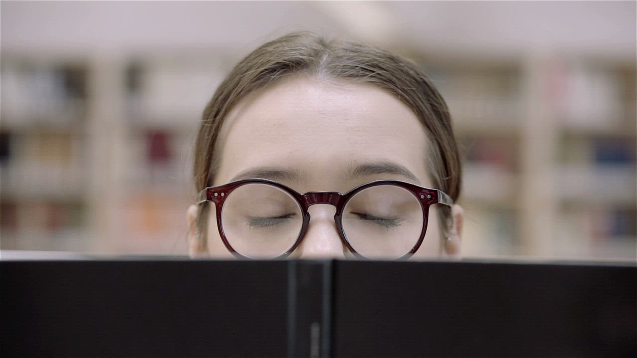 Woman eyes with glasses reading a book - Free Stock Video