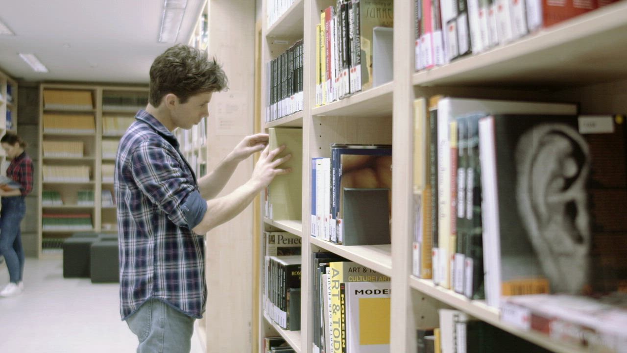 Man looking for a book in the library - Free Stock Video