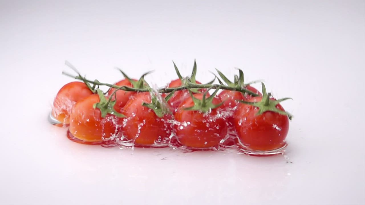 Several ripe tomatoes falling on the table - Free Stock Video