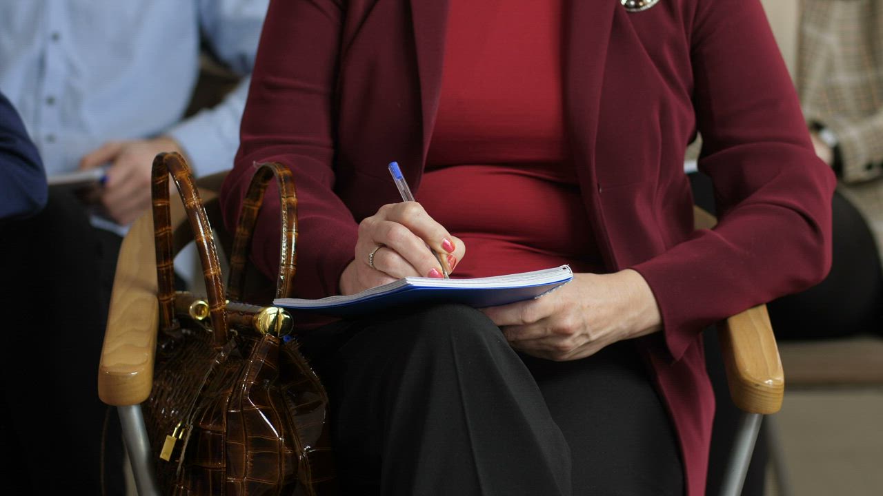 Writing in a notepad at a conference - Free Stock Video