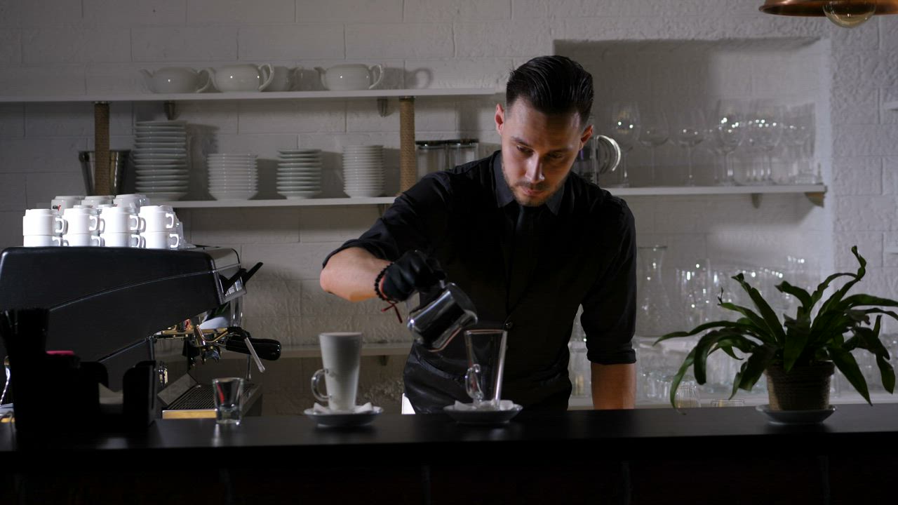 Barista filling a pitcher with milk - Free Stock Video