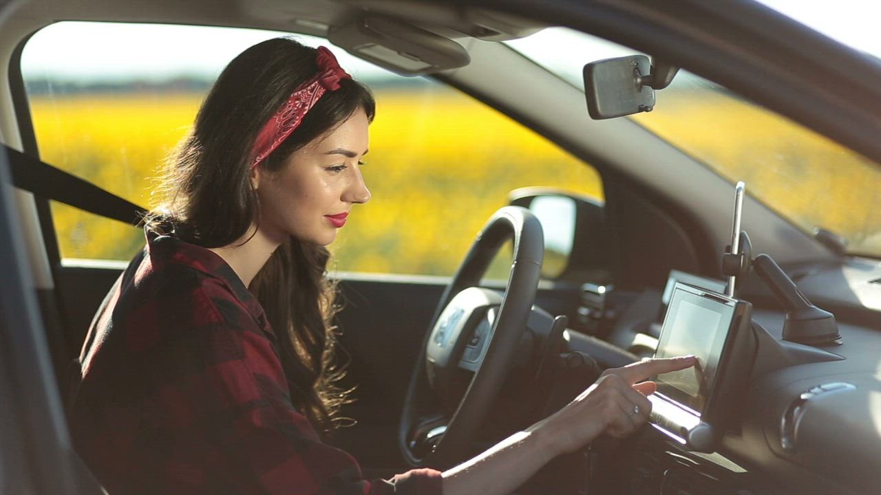 Woman setting up her GPS for a trip - Free Stock Video