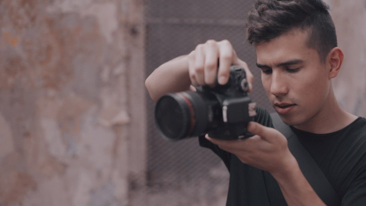 Photographer reviewing his shots in the camera's screen - Free Stock Video