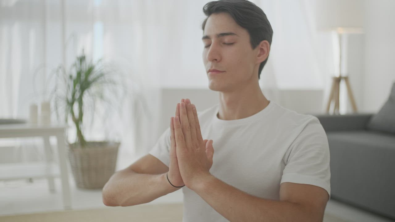 Closeup of man in Namaste yoga pose in living room - Free Stock Video