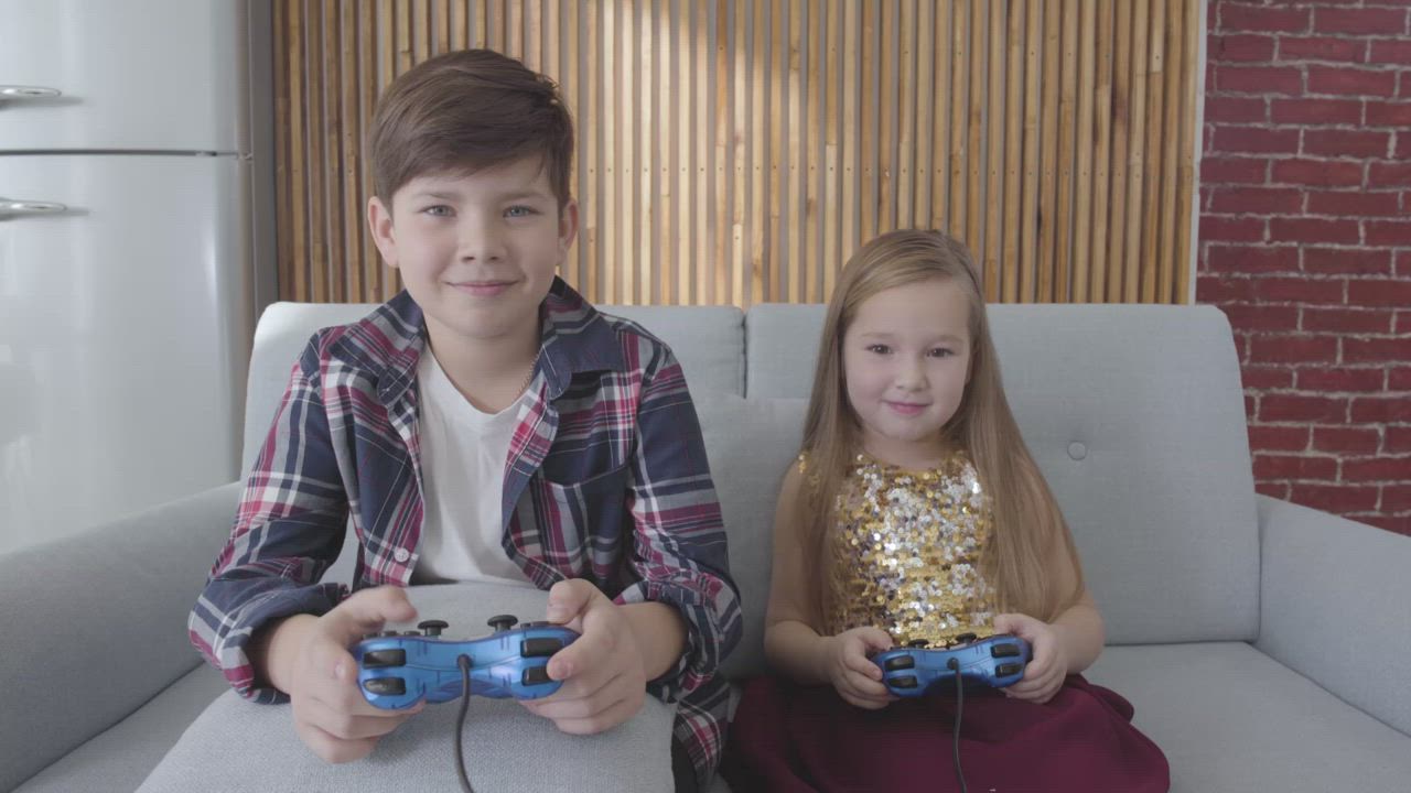 Two kids play console games and celebrate win - Free Stock Video