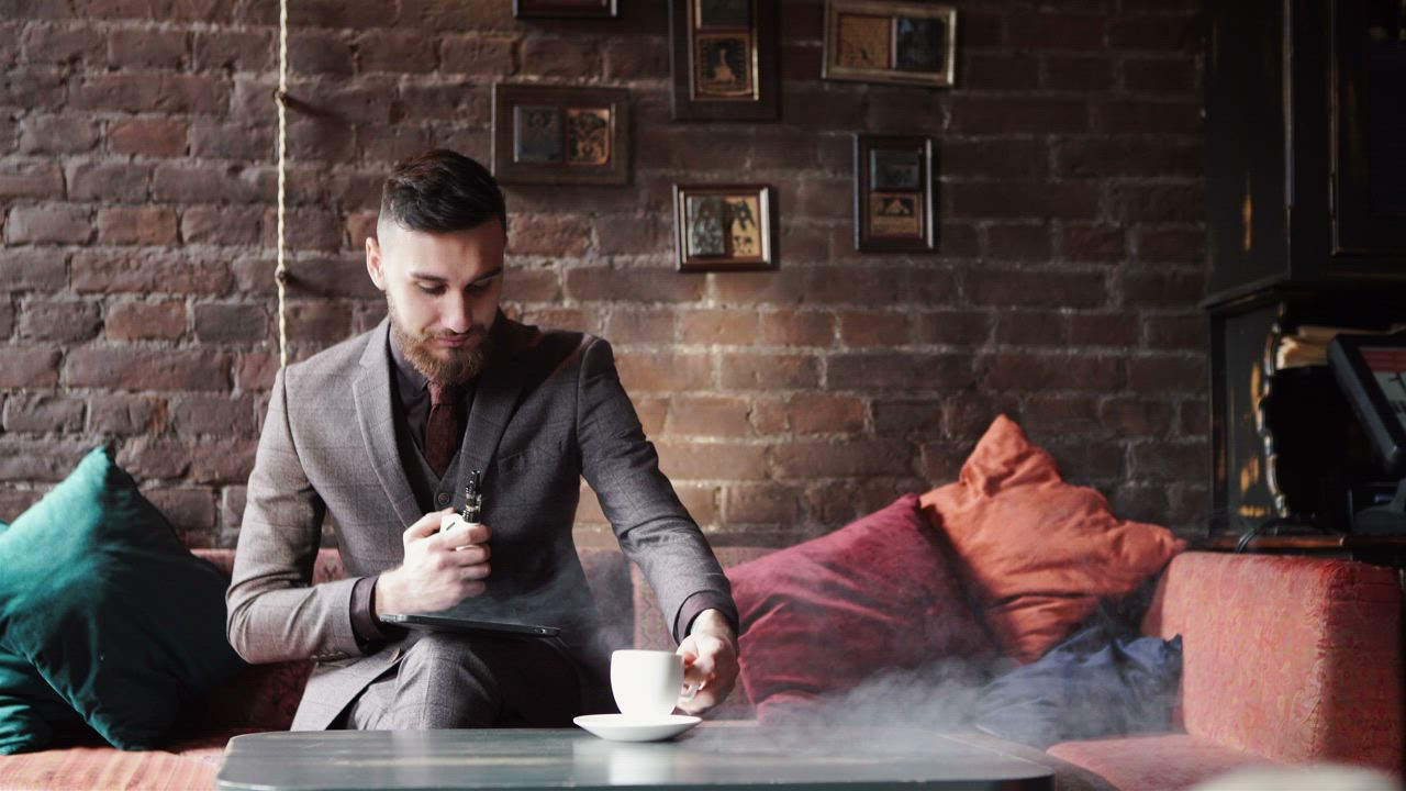 Stylish man in suit smoking in coffee shop - Free Stock Video