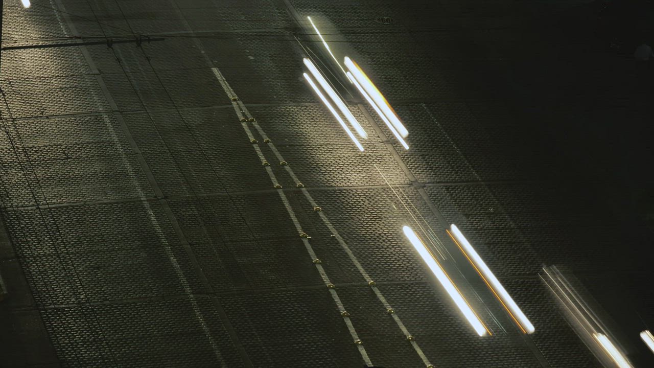 Cars drive on a two way street at night - Free Stock Video