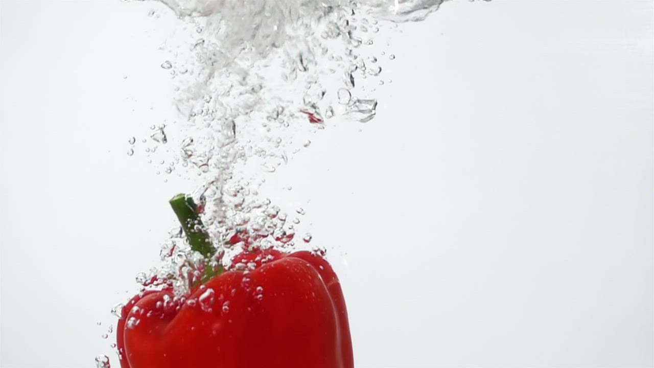 Red pepper falling through water - Free Stock Video