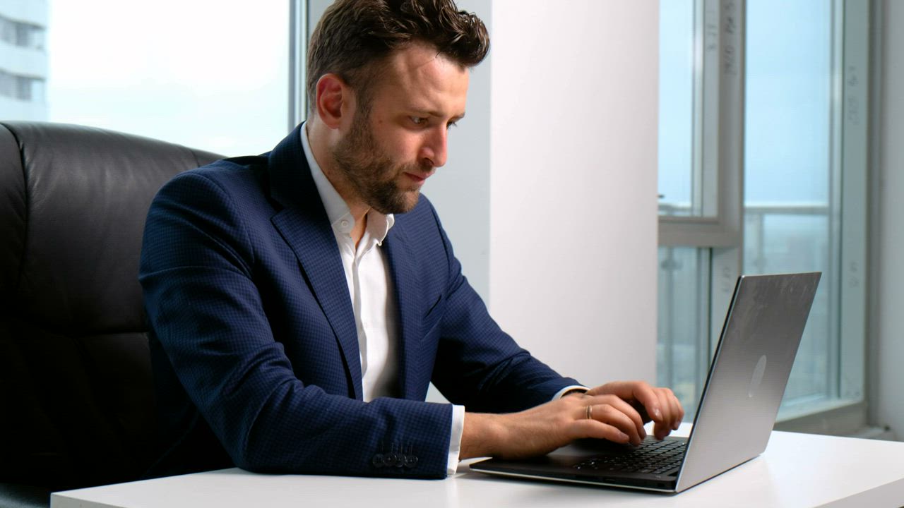 Lawyer types on laptop in highrise office with city view - Free Stock Video