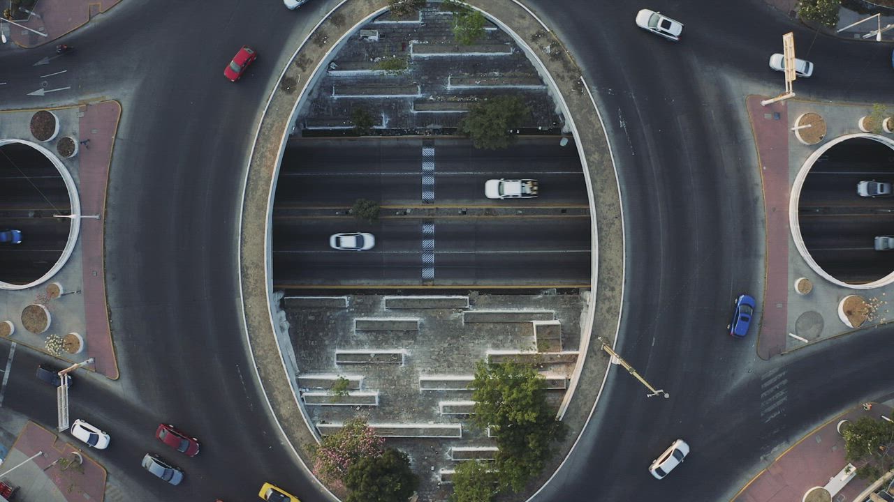 City traffic going around a roundabout from above - Free Stock Video