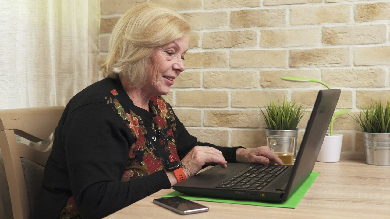 Elderly woman using a laptop - Free Stock Video