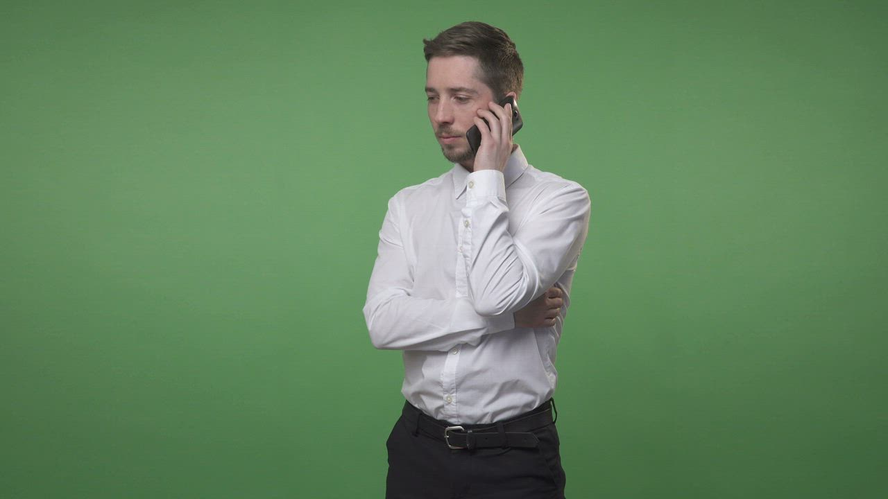 Man talking on his phone against a screen - Free Stock Video