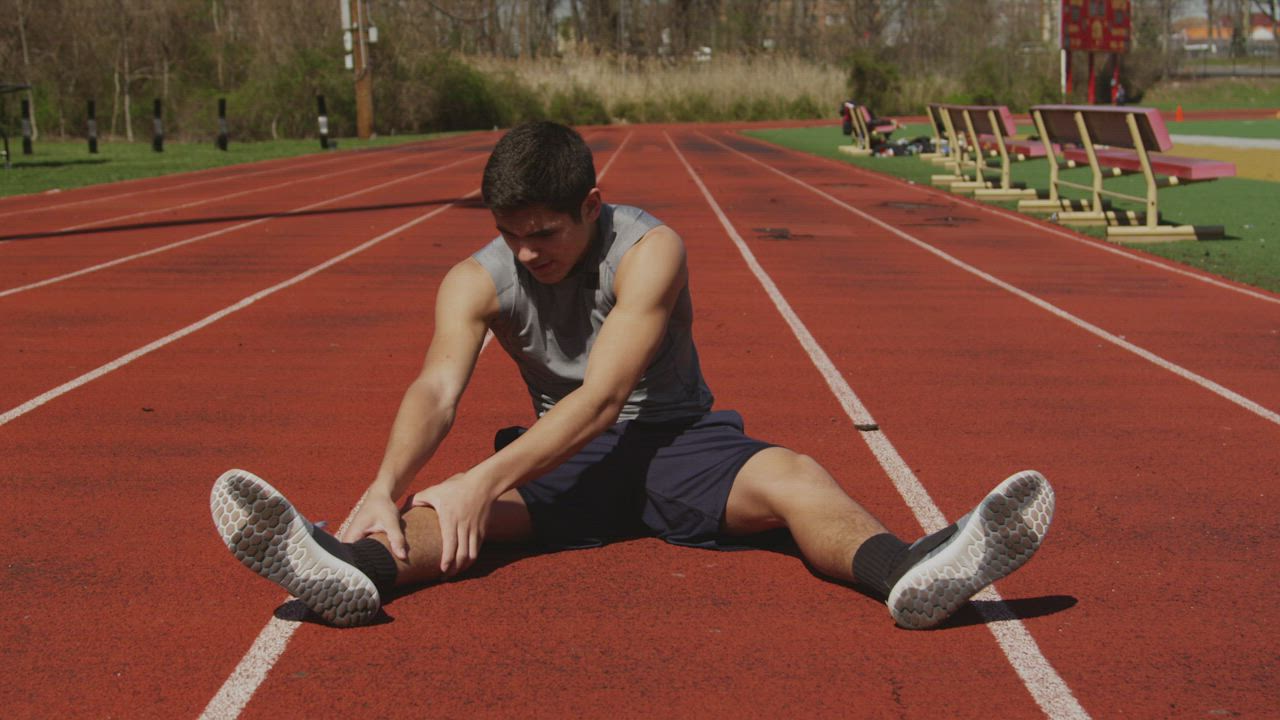 Man stretching at a running track - Free Stock Video