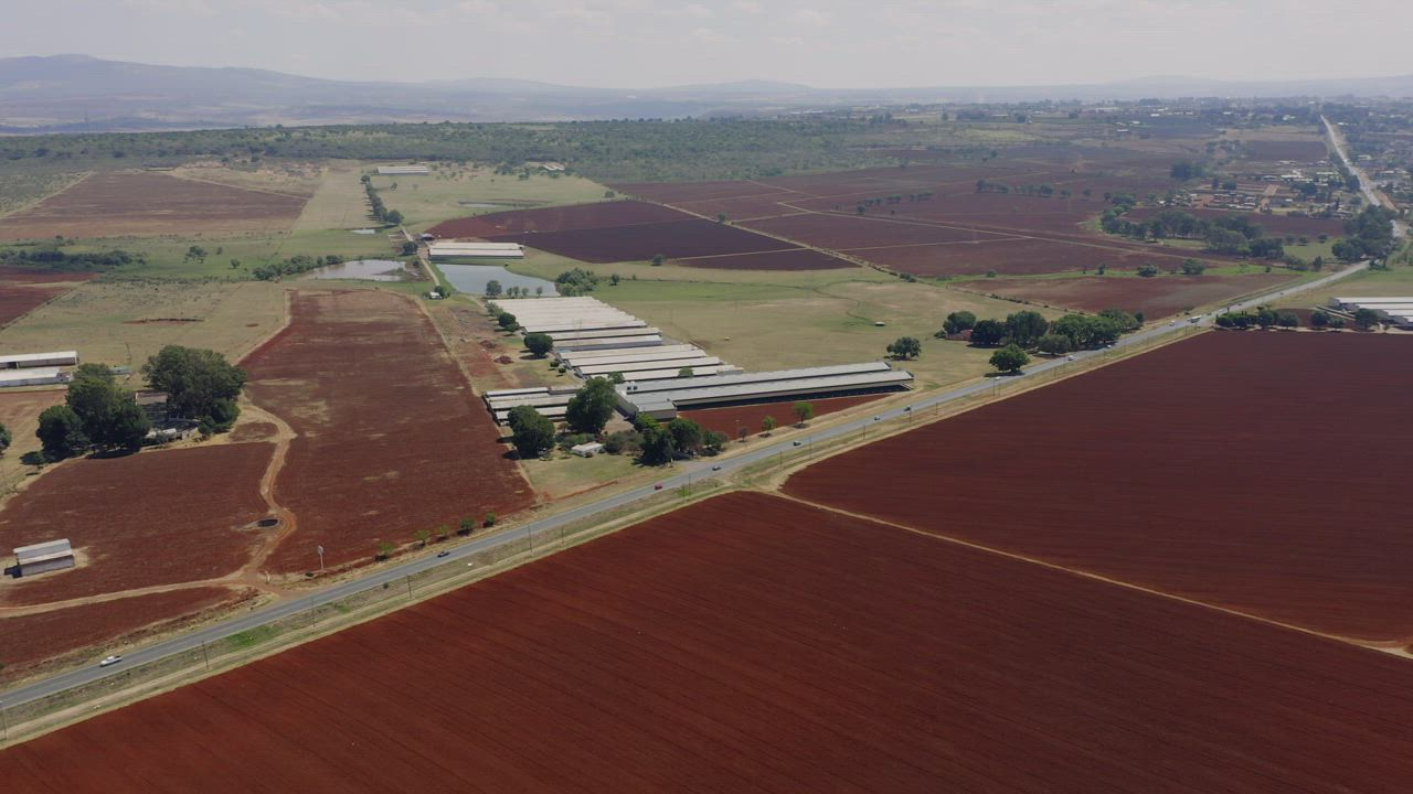 Aerial view of a freeway with farms next to it - Free Stock Video