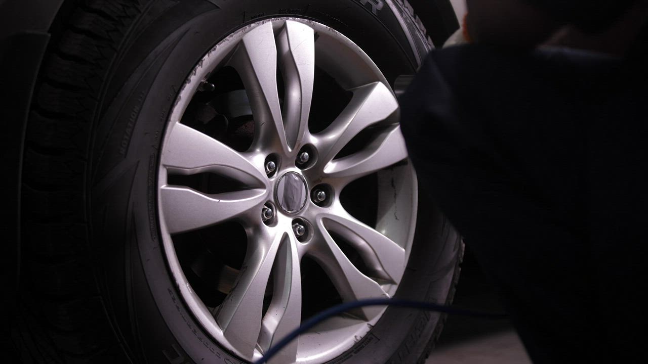 Taking a wheel off of a car - Free Stock Video