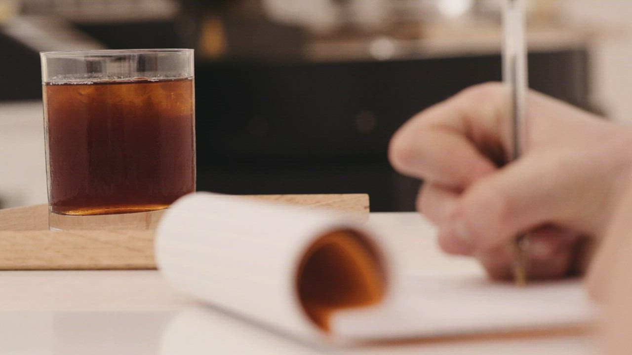 A coffee drinker taking notes - Free Stock Video