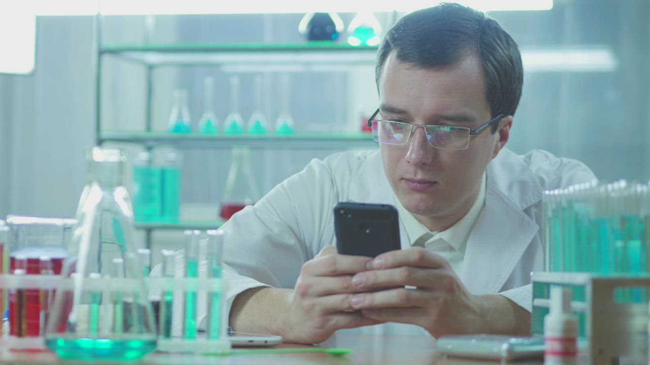 Laboratory scientist looking at the phone - Free Stock Video