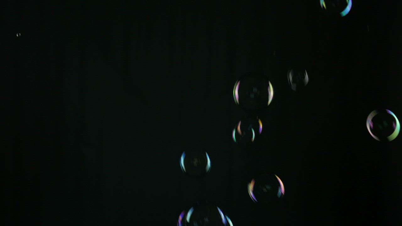 Bubbles falling on a black background - Free Stock Video