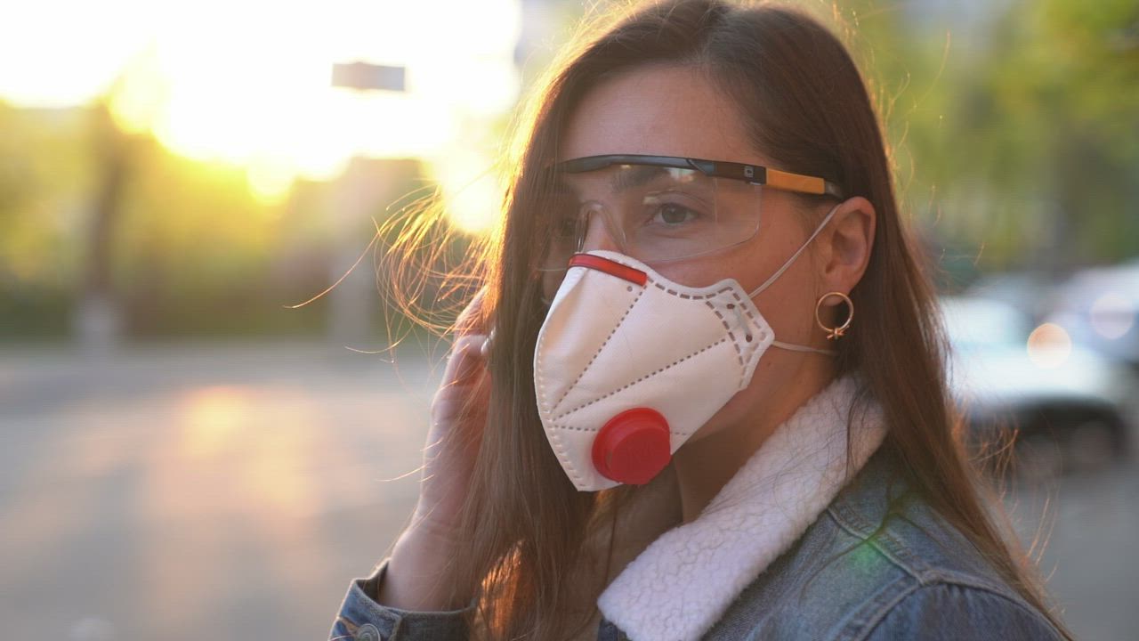 Woman using a face mask in the street - Free Stock Video