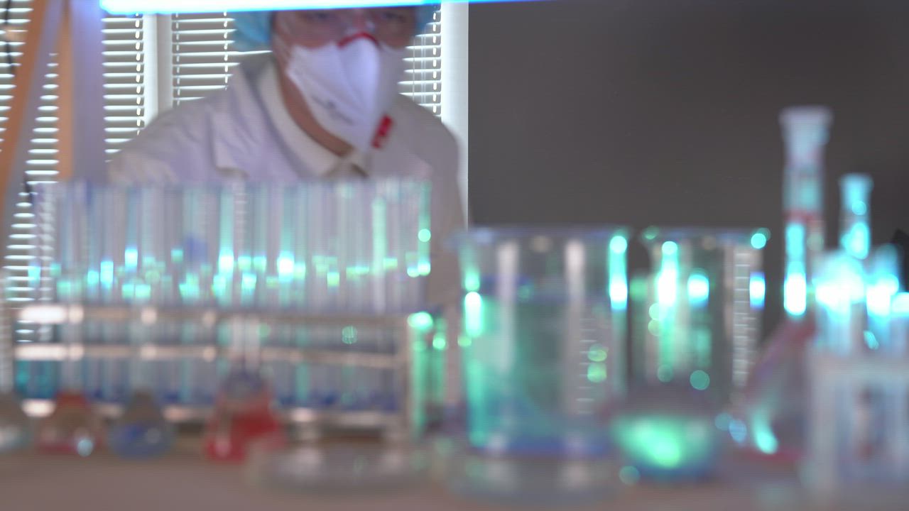 Scientist mixing components on flasks - Free Stock Video