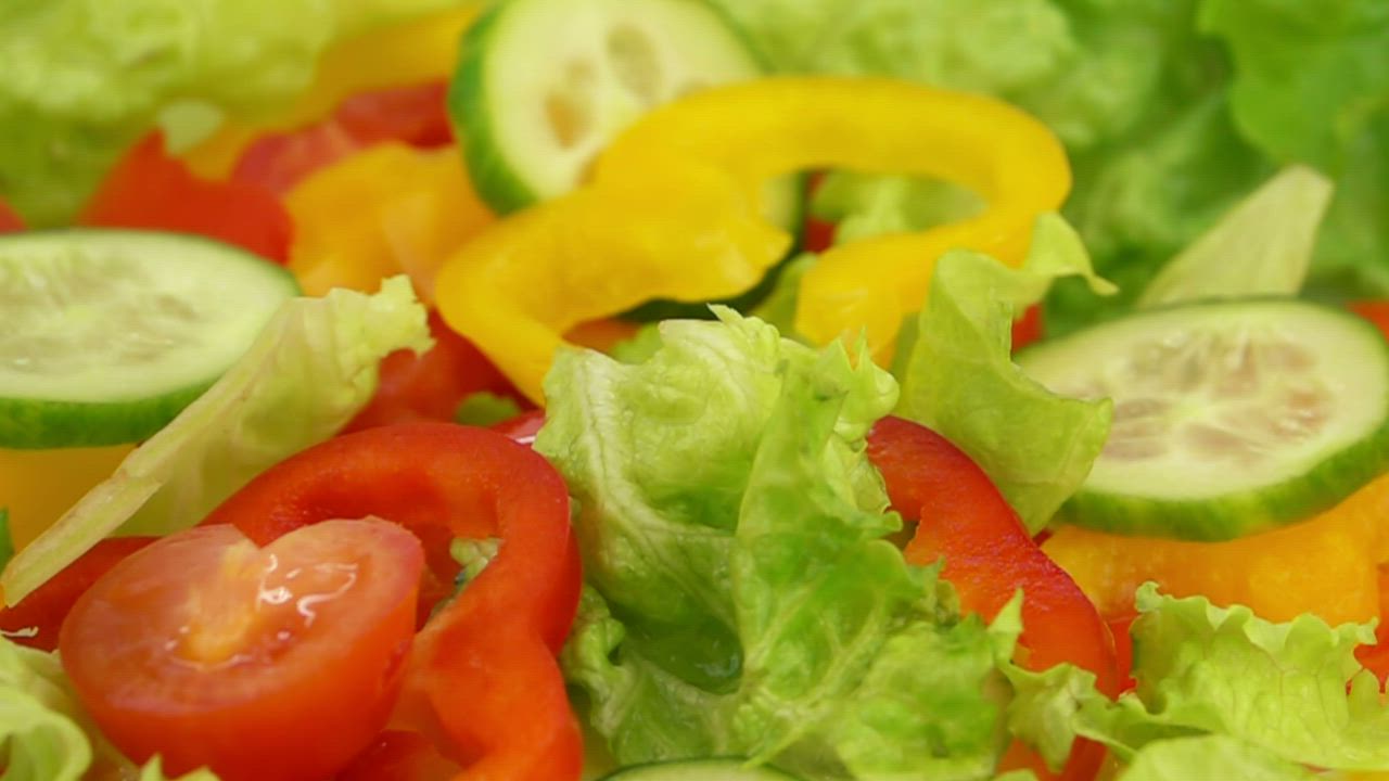 Slices of vegetables falling over salad - Free Stock Video