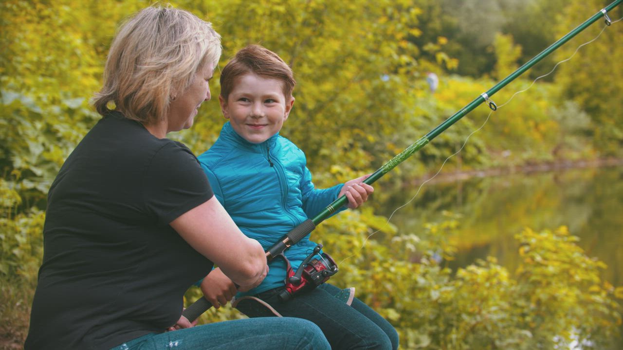 Woman teaching a boy to fish - Free Stock Video