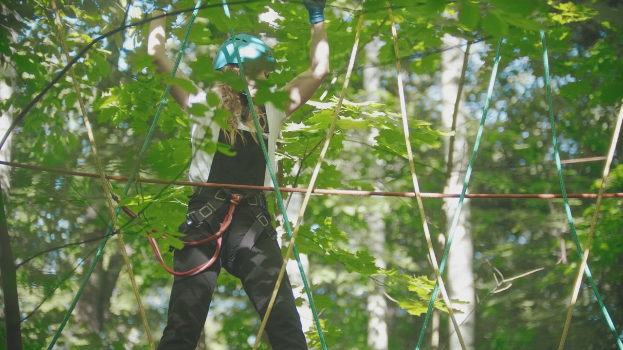 Young woman crossing the ropes in the woods - Free Stock Video
