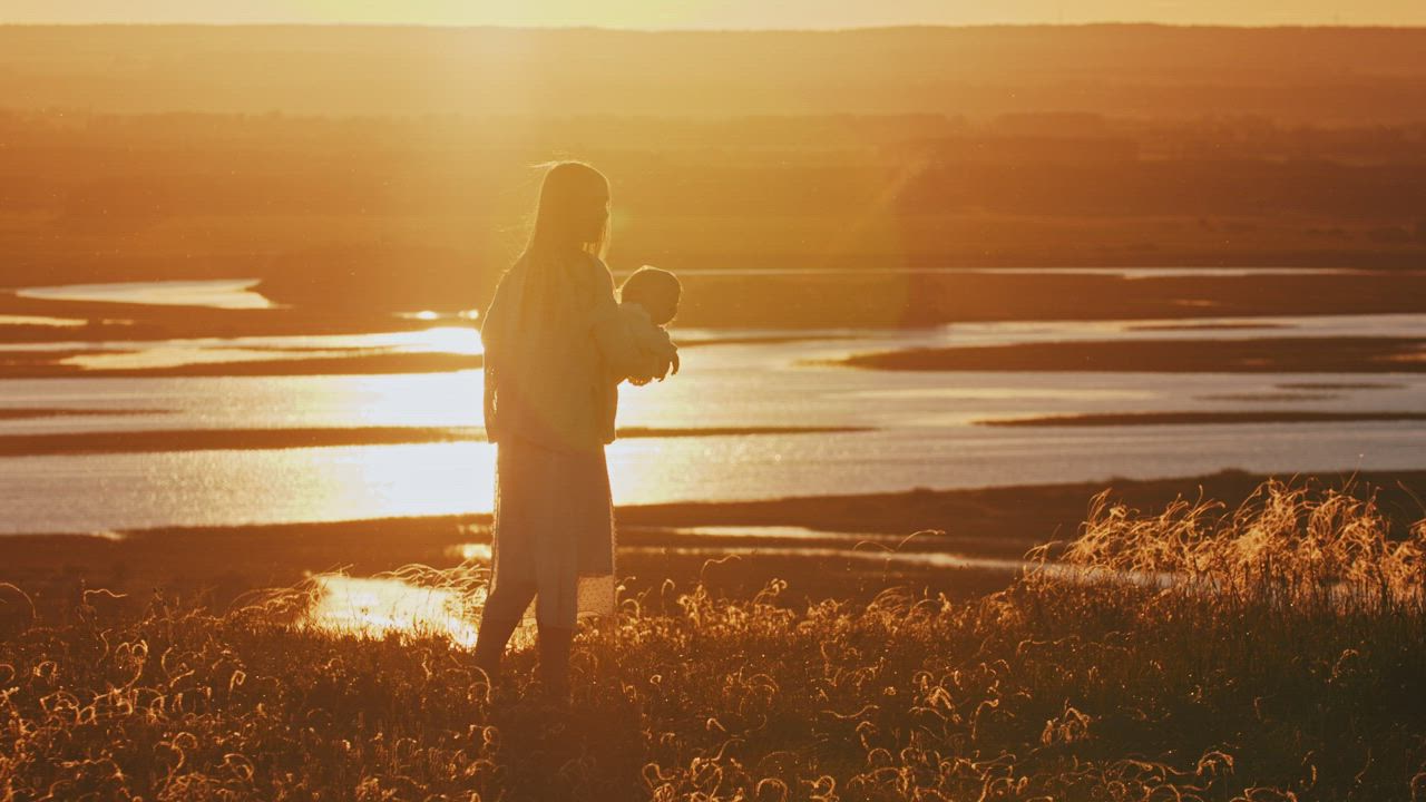 Woman and her baby spinning at sunset - Free Stock Video