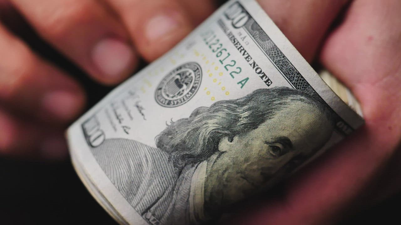 Hands flipping through a wad of dollars seen very close - Free Stock Video