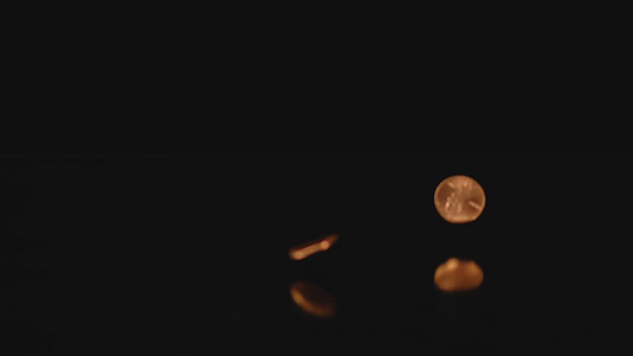 Pennies falling on a reflective surface with a dark background - Free ...