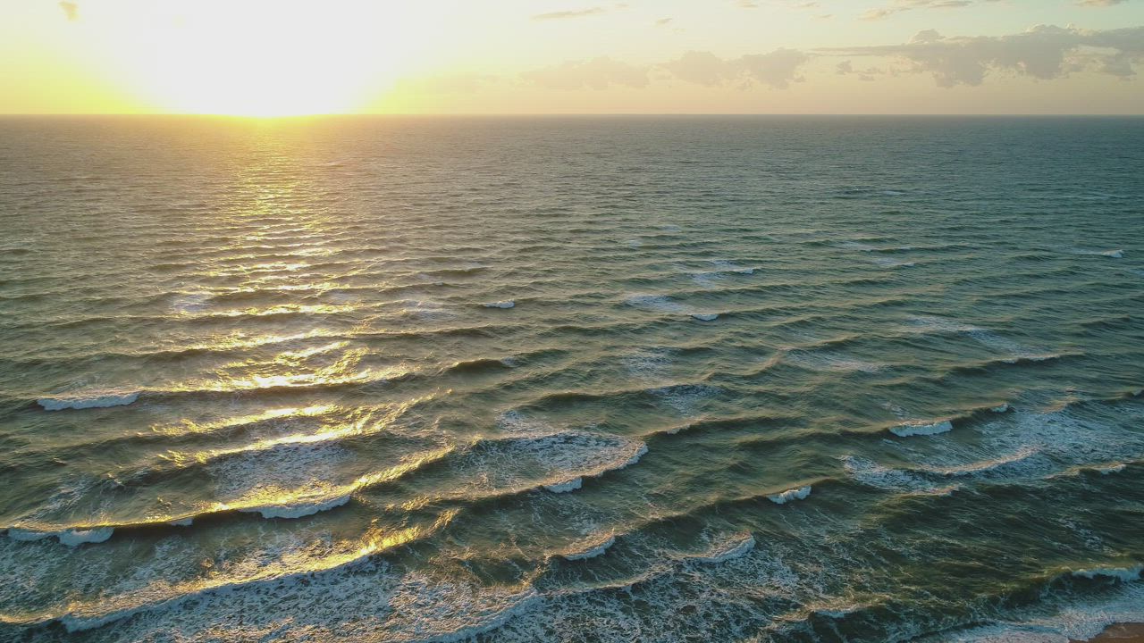 The calm sea at dawn on the seashore - Free Stock Video
