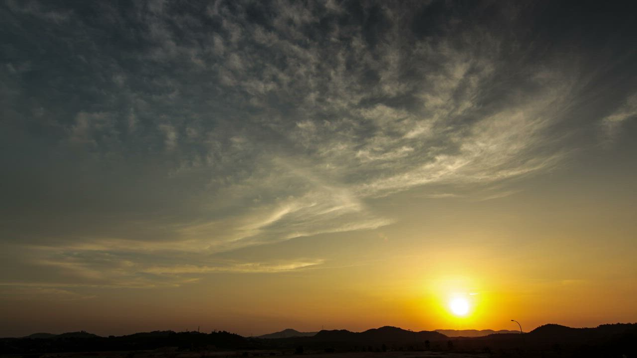 Sun setting across dark hills - Free Stock Video