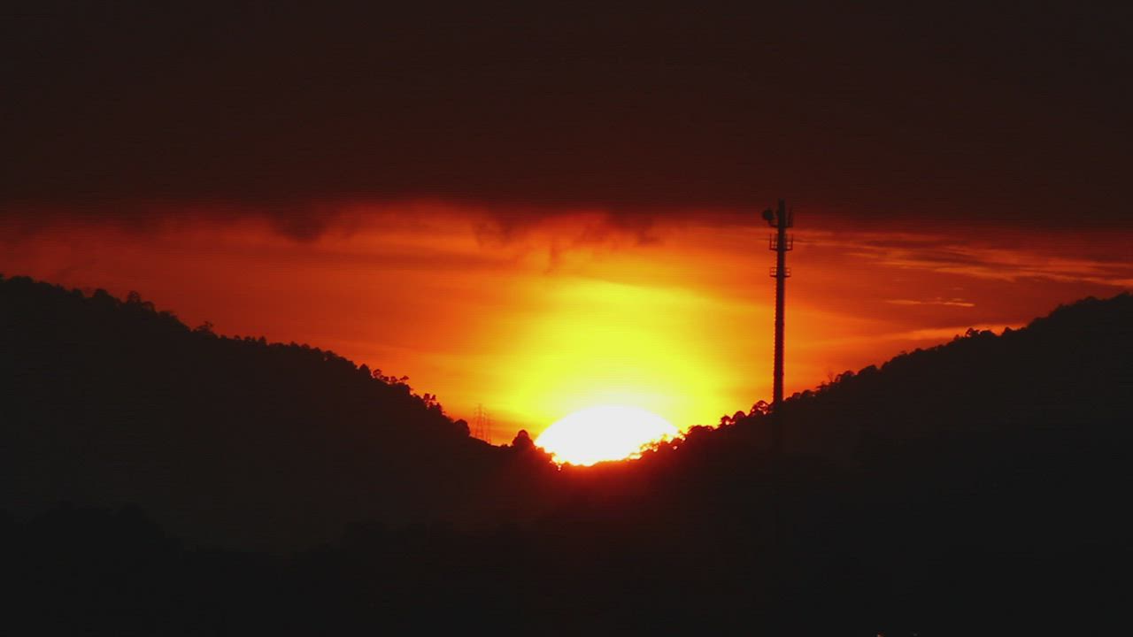 Sun rising towards dark clouds - Free Stock Video