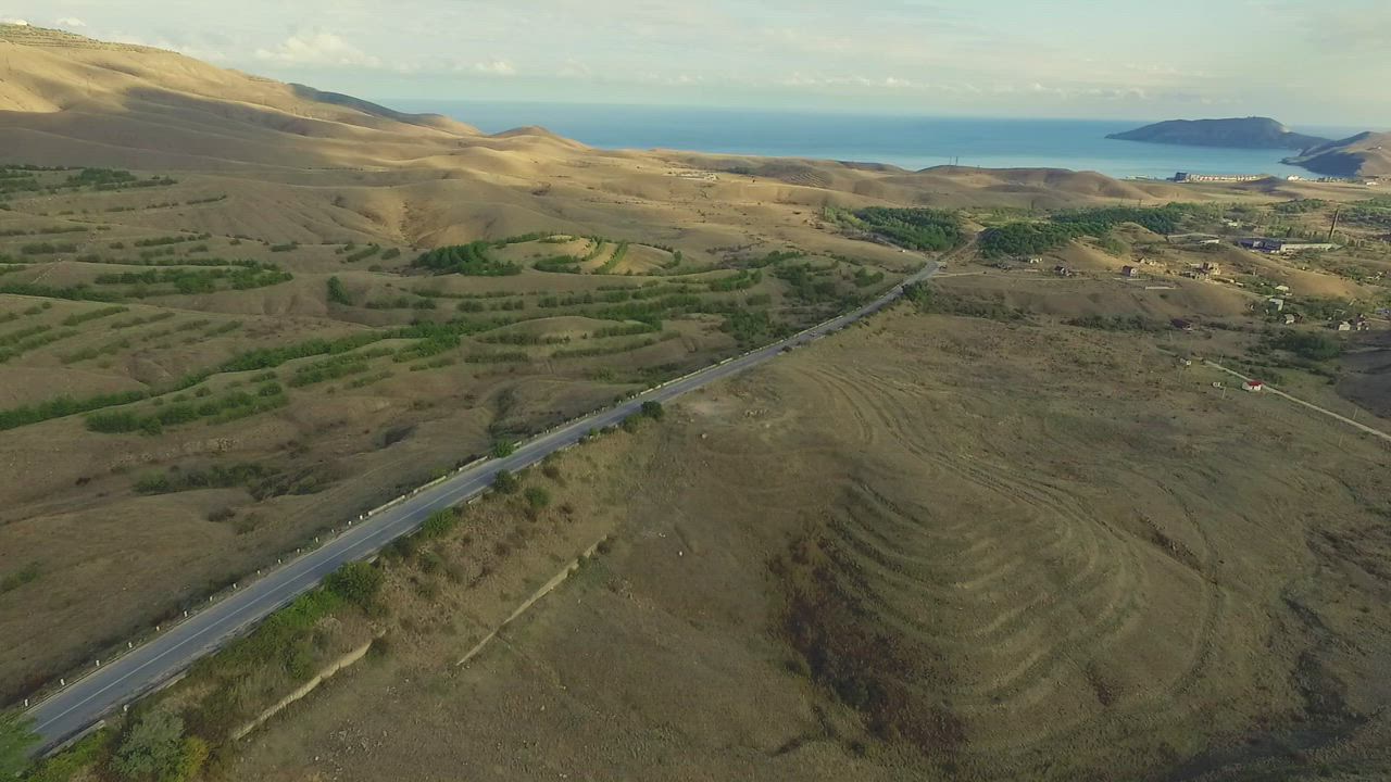 Desert road leading to the open ocean - Free Stock Video