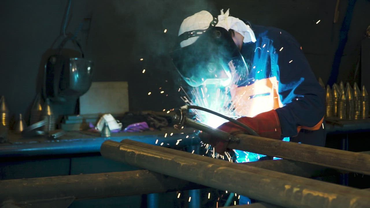 Welding by hand in a workshop - Free Stock Video