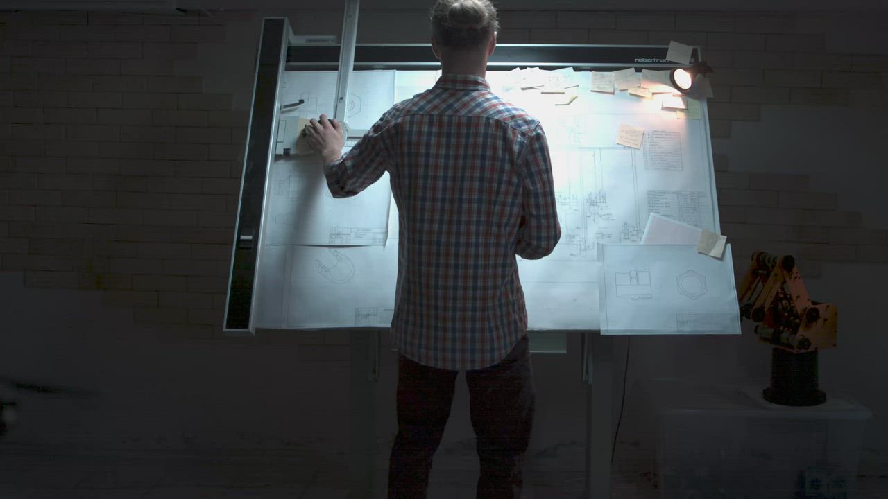 Engineer looking over plans on a board - Free Stock Video